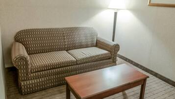 Quarto com sofá estampado e mesa de centro de madeira.