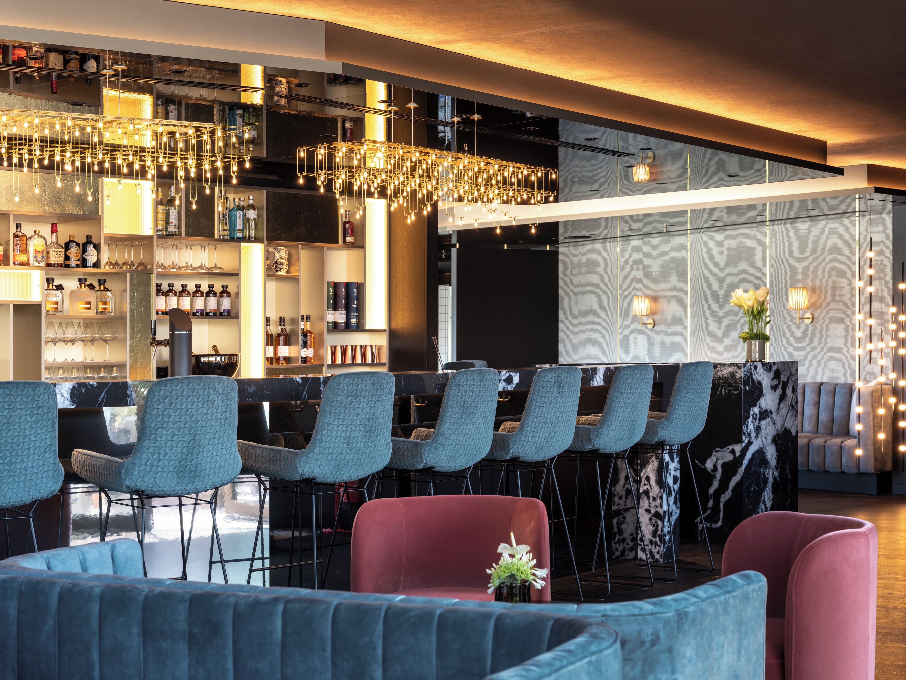 Uma área de bar moderna com assentos e balcão.