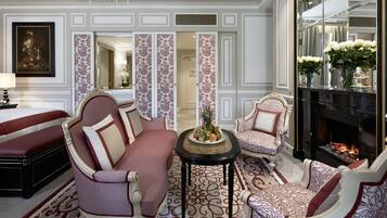 Uma sala de estar luxuosa com sofá, poltronas, mesa de centro e lareira.