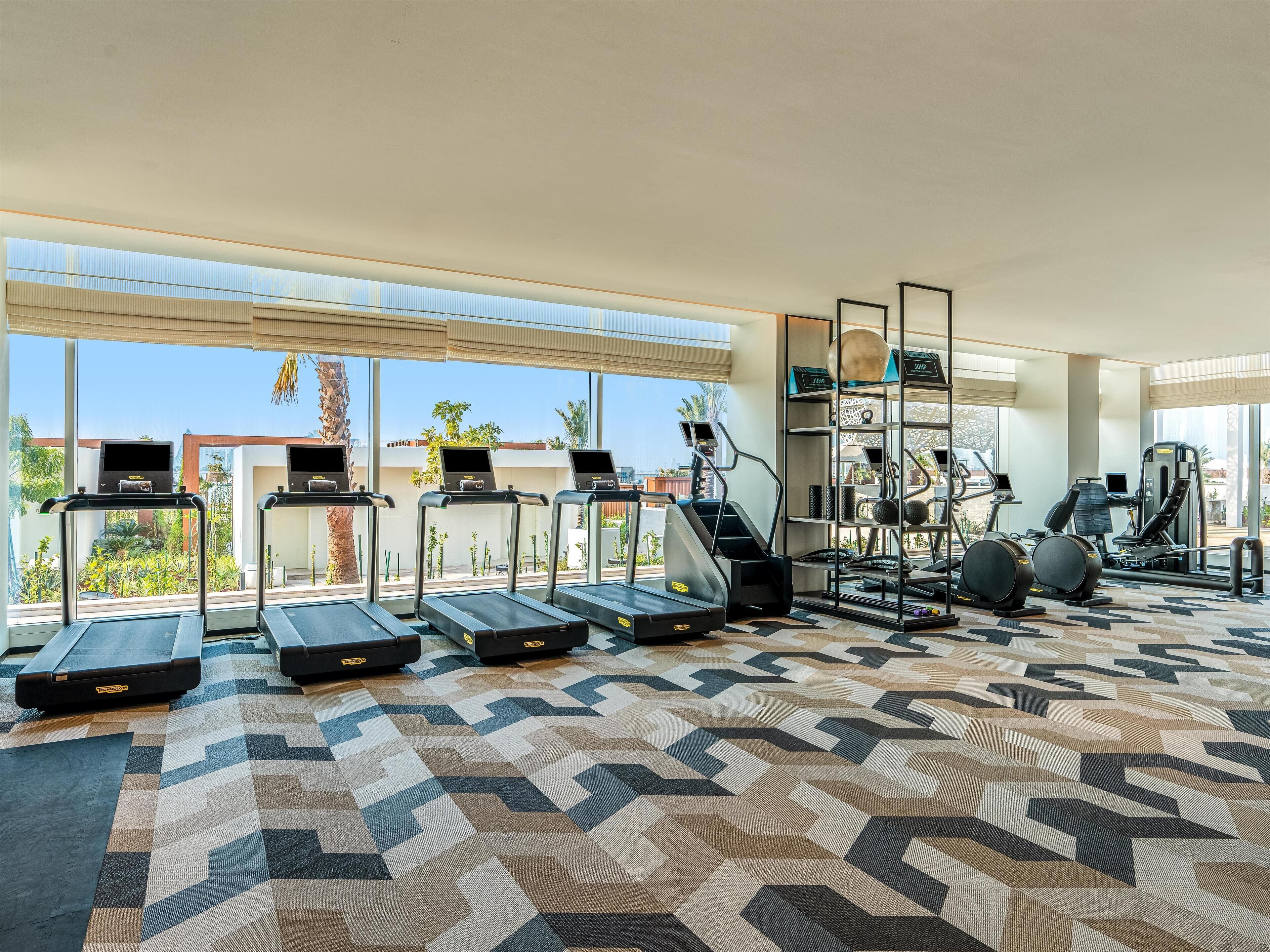 Academia com esteiras, elípticos e equipamentos de musculação.