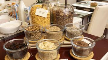 Diversos alimentos expostos em recipientes de vidro sobre uma mesa de madeira, incluindo cereais, nozes e sementes.