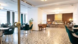 Um hall de hotel com área de bar, disposição de assentos e piso de mármore.