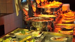Uma mesa com vários pratos e utensílios em estilo buffet.