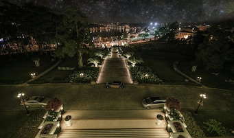 Vista noturna de uma escadaria bem iluminada que leva a um edifício de arquitetura tradicional.