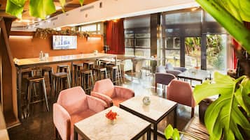 Um restaurante moderno com área de bar, mesas e cadeiras, e amplas janelas que oferecem vista para o exterior.