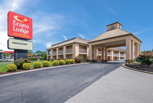 Um hotel com uma grande placa de Econo Lodge Inn & Suites, entrada coberta e estacionamento.