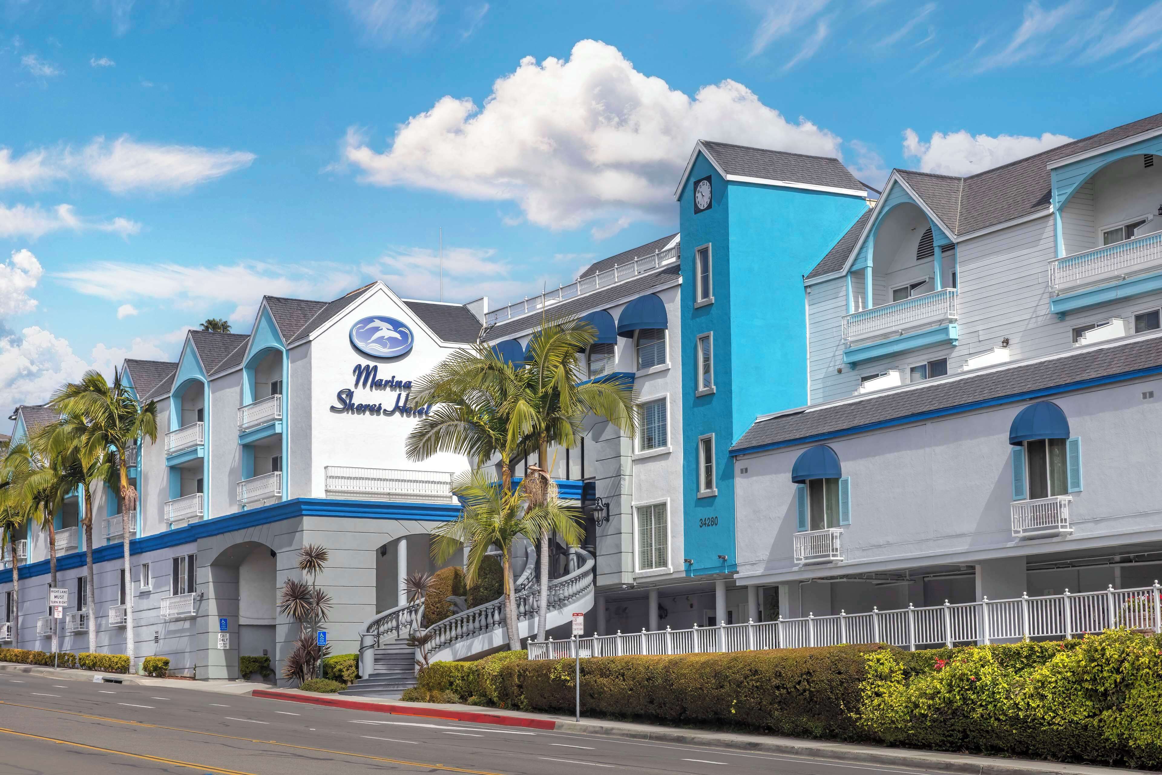 Um hotel com um grande letreiro 'Marquis', várias varandas e uma escadaria que leva à entrada.