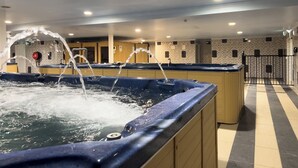Uma área de banhos públicos com várias banheiras de hidromassagem e jatos de água.