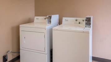 Duas máquinas de lavar roupa Whirlpool, uma sobre a outra, numa lavanderia.