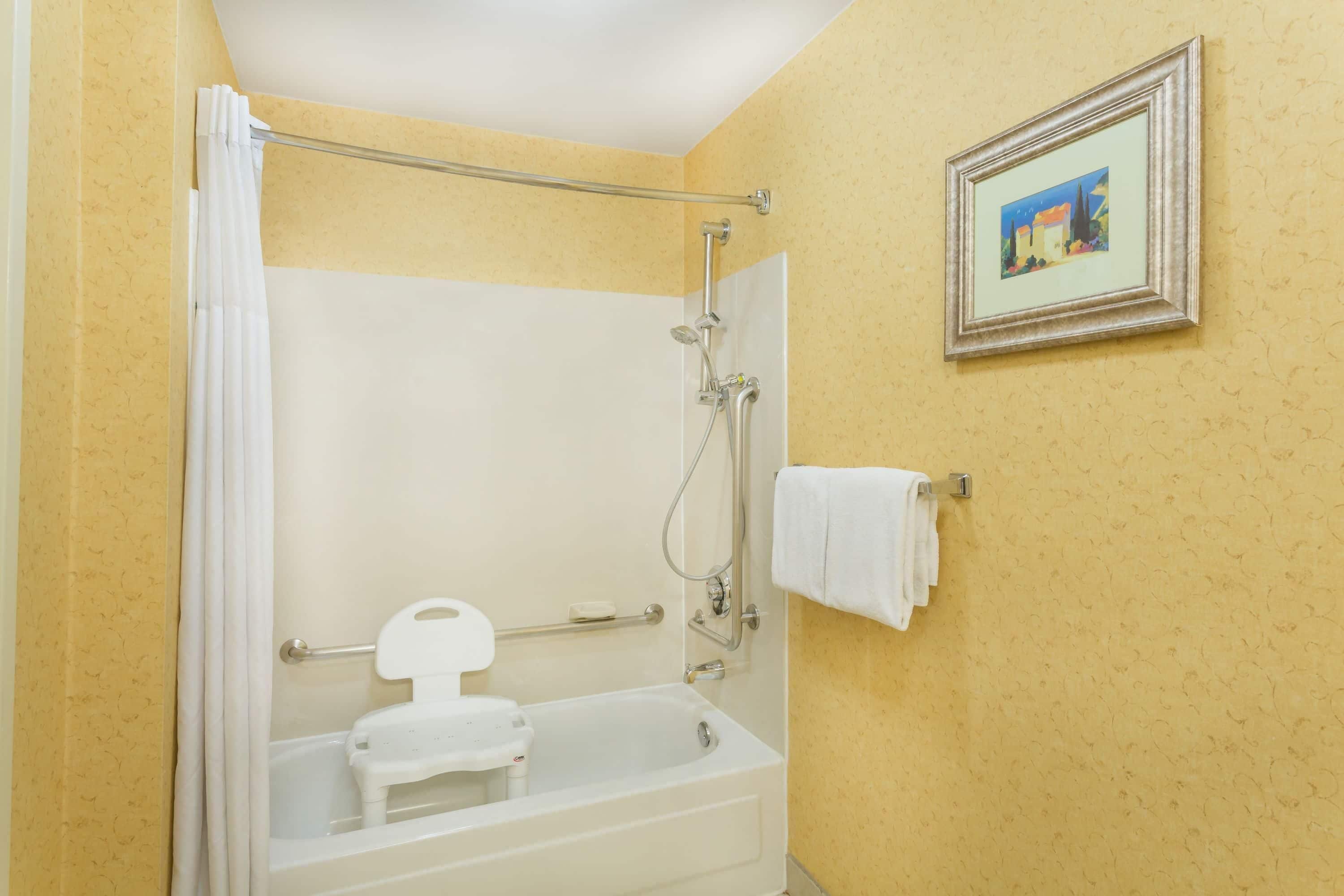 Casa de banho com banheira, chuveiro e um porta-toalhas.