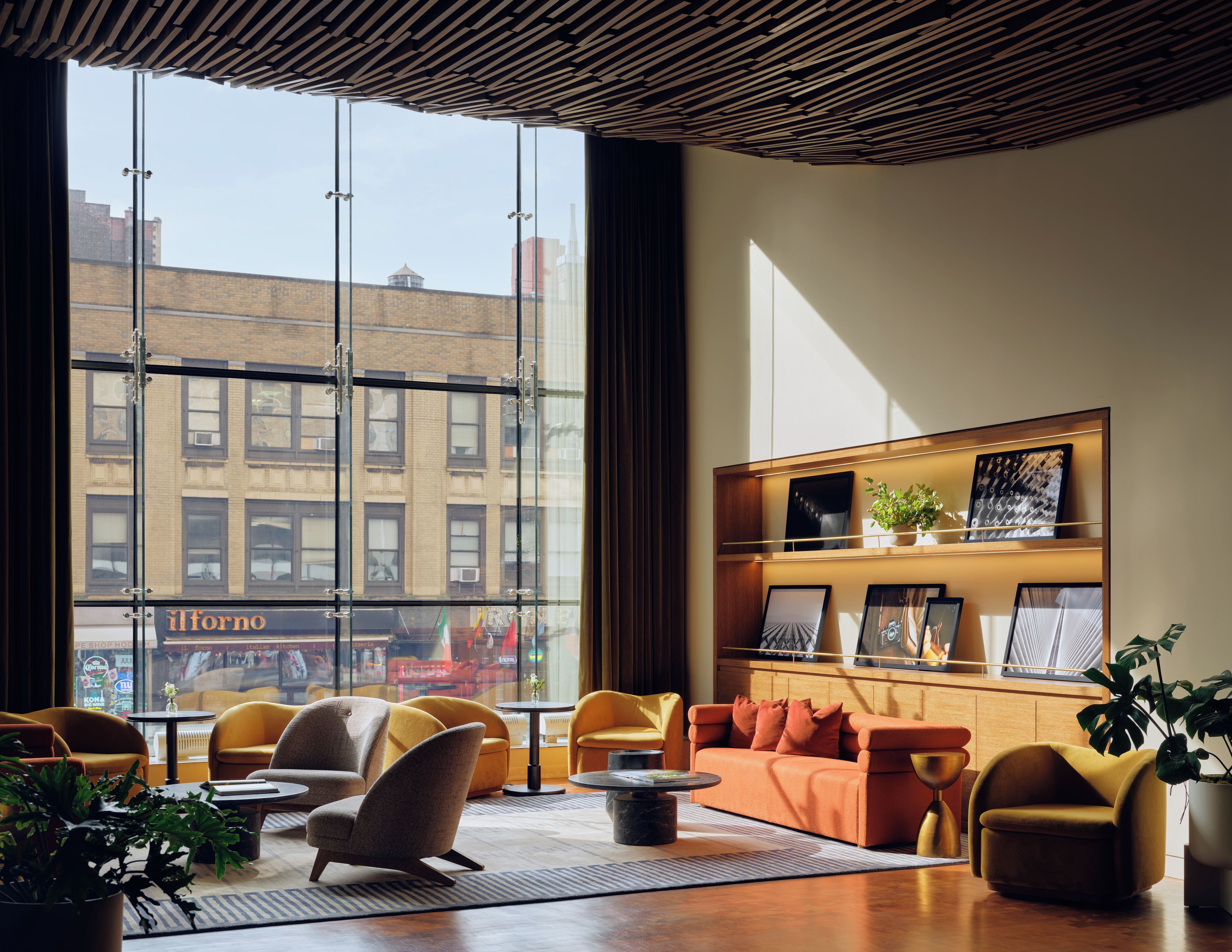 Um interior moderno com sofá, poltronas, mesa de centro e estante de livros.