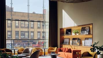 Um interior moderno com sofá, poltronas, mesa de centro e estante de livros.