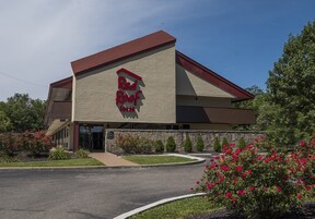 Um edif ício com telhado vermelho e uma placa que diz 'Red Roof Inn'.