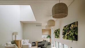 Uma sala de estar moderna com teto alto, janelas amplas e design minimalista.