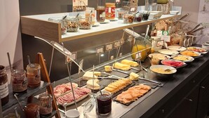 Um buffet com diversos alimentos e acompanhamentos.