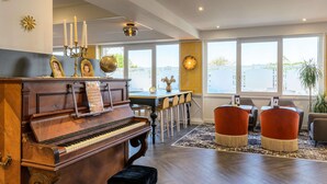 Pianinho, sala de jantar e área de estar com vista.