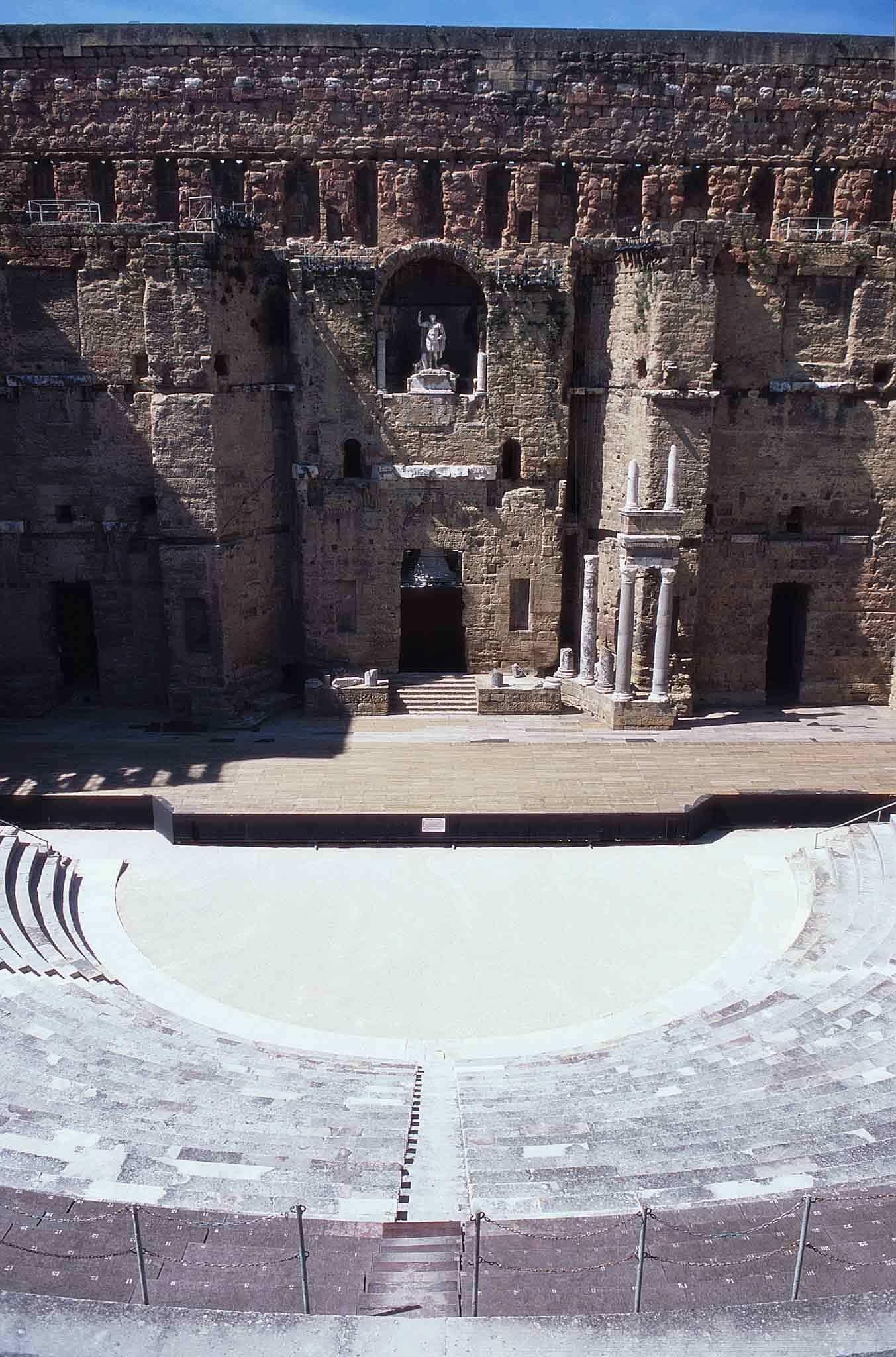 Um edifício histórico com um pátio central e uma estátua.