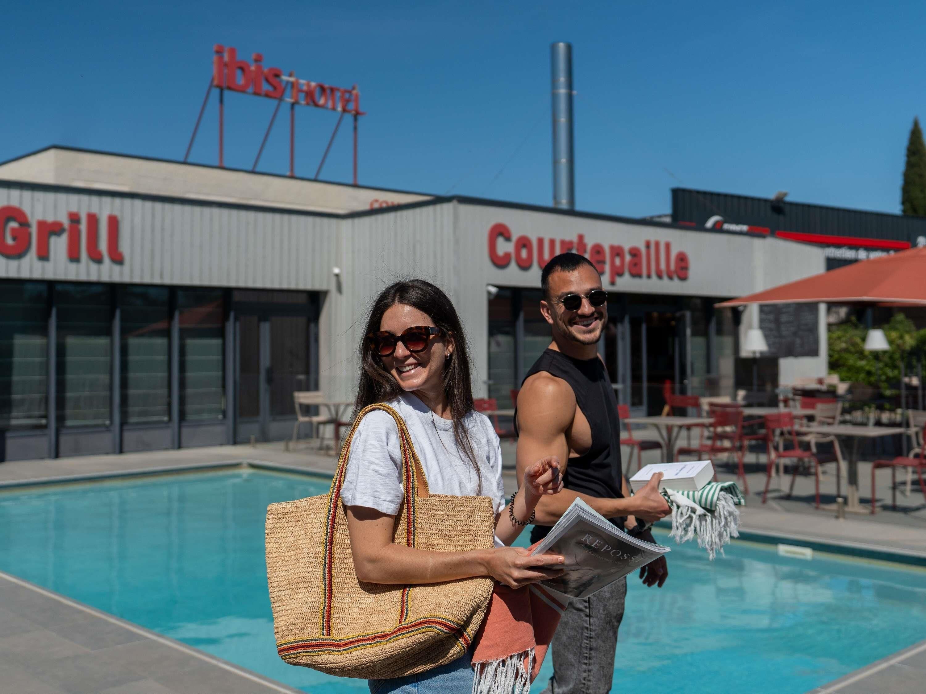 Área de piscina com um edifício ao fundo identificado com os dizeres 'Grill' e 'Courtepaille'.
