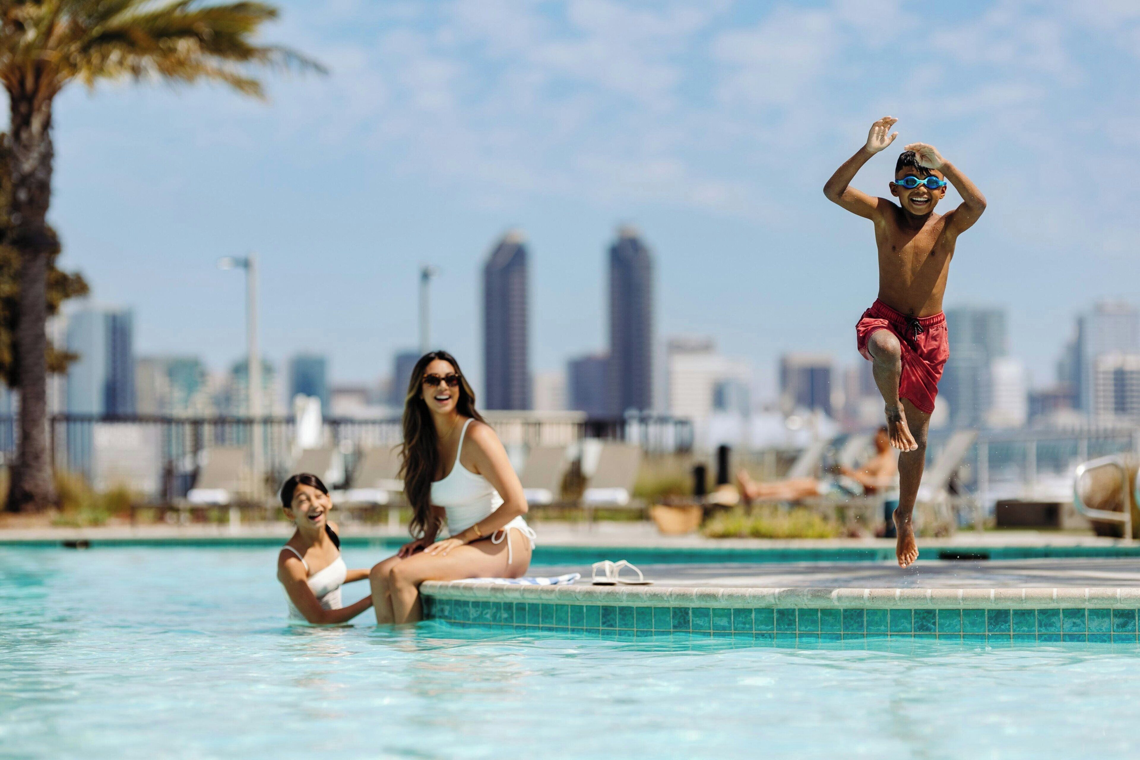 Piscina com edifícios da cidade ao fundo.