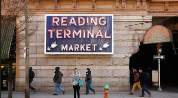 Um edifício com uma grande placa que diz 'READING TERMINAL MARKET'.