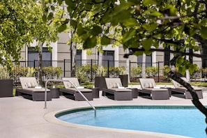 Uma área à beira da piscina com espreguiçadeiras e uma piscina.