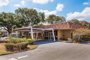 Hotel com posto de combustível, estacionamento coberto e céu limpo.