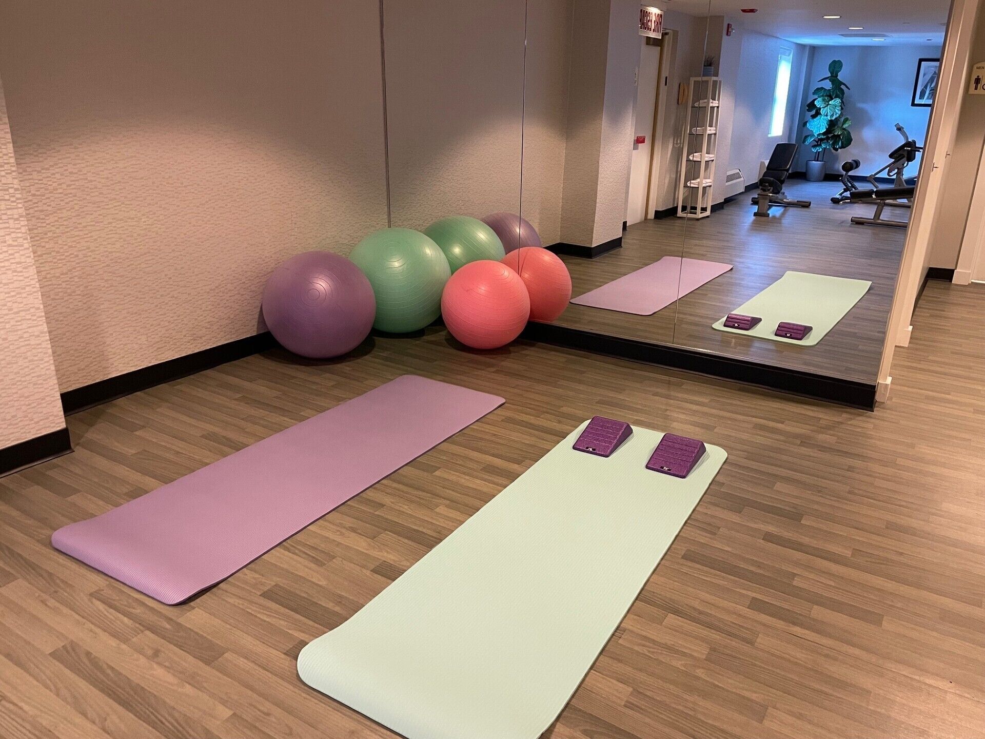Espaço de ginástica com colchonetes, bolas e equipamentos.