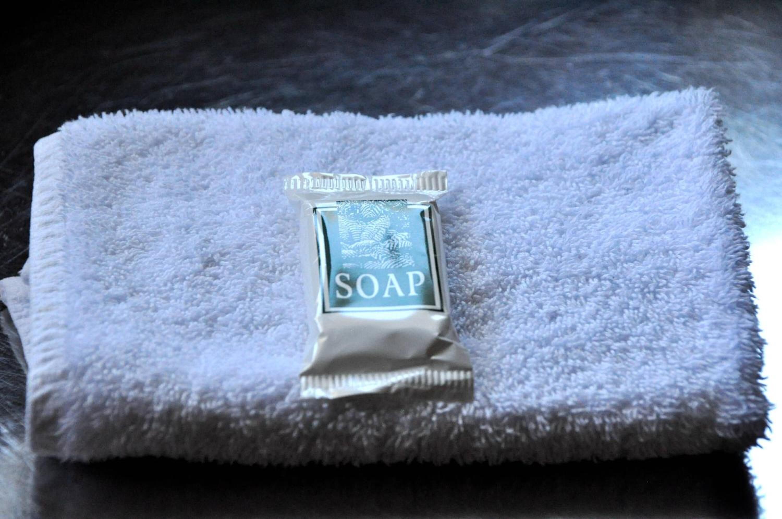 Uma toalha branca com uma barra de sabonete prata com a etiqueta 'SOAP'.