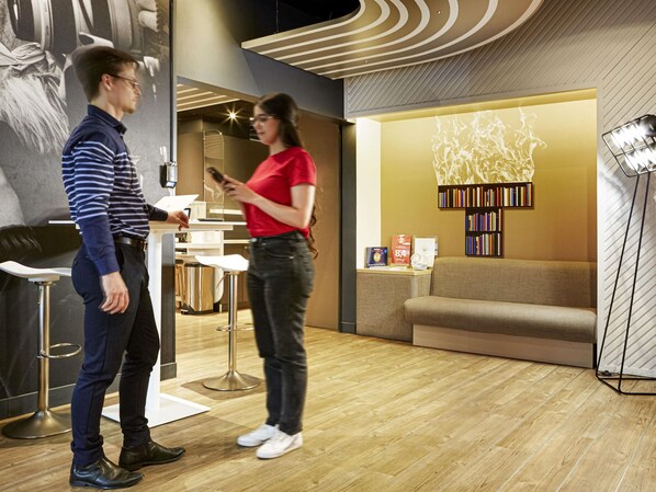 Um interior moderno com área de bar, sofá e estante.