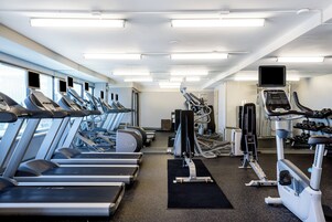 Academia com esteiras, elípticos e equipamentos de musculação.
