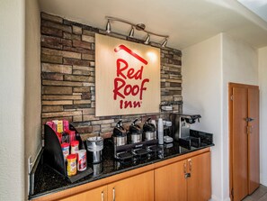 Uma cozinha com uma placa indicando 'Red Roof Inn' acima de uma parede de pedra.