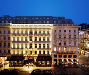 Um hotel com vários andares, de estilo arquitetônico europeu clássico, com fachadas ornamentadas e grandes janelas.