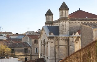 Um edifício histórico com uma torre imponente e janelas em arco.