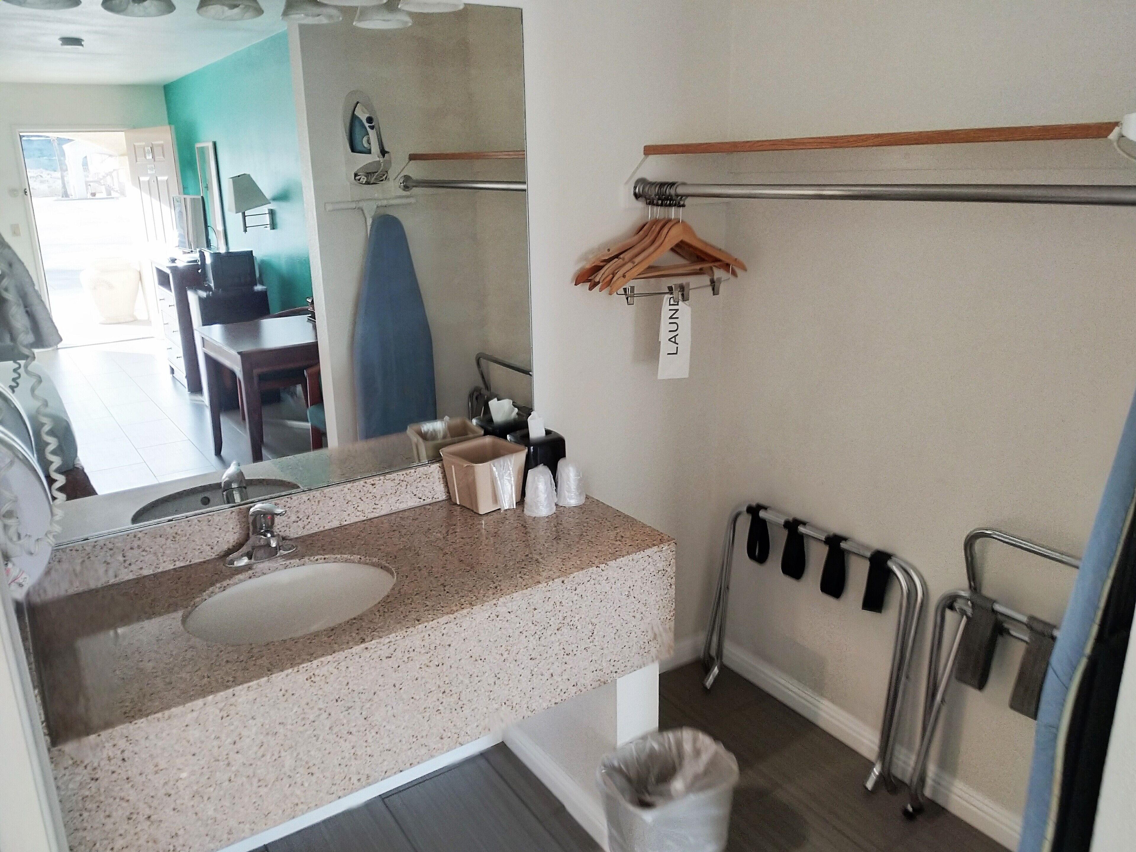 Uma casa de banho com pia, espelho, porta-toalhas e zona de duche.