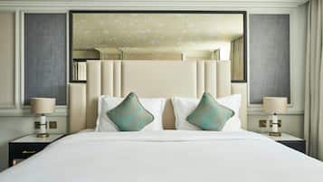 Quarto de hotel com uma cama grande, duas mesas de cabeceira e um espelho sobre a cama.