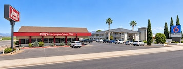 Um edifício comercial com fachada vermelha e placa indicando 'Jerry's Restaurant', com um estacionamento em frente.