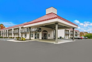 Hotel com telhado vermelho, várias varandas e entrada coberta.