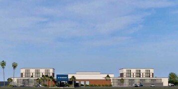 Um edifício moderno com telhado plano, janelas grandes e uma placa azul.