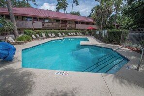 Piscina com espreguiçadeiras e aviso de proibição de mergulho.