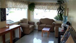 Quarto com sofá, uma mesinha e janela com vista para o exterior.