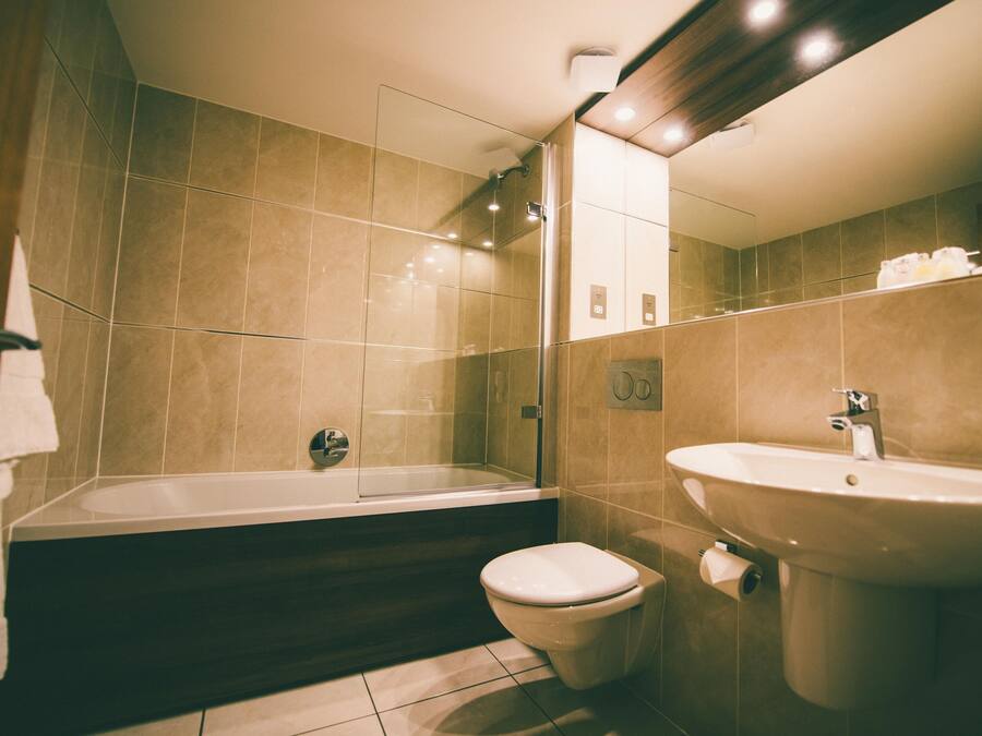 Uma casa de banho moderna com banheira, sanita e lavatório.