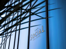 Fachada de um edifício com uma placa que diz 'The Social Bar & Bistro'.