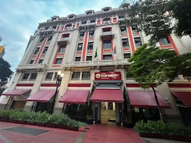 Um hotel com toldo vermelho, uma placa indicando "Hotel Eurosuite São Paulo Centro" e uma bandeira.