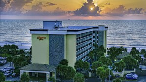 Um hotel com piscina, estacionamento e vista para o oceano.