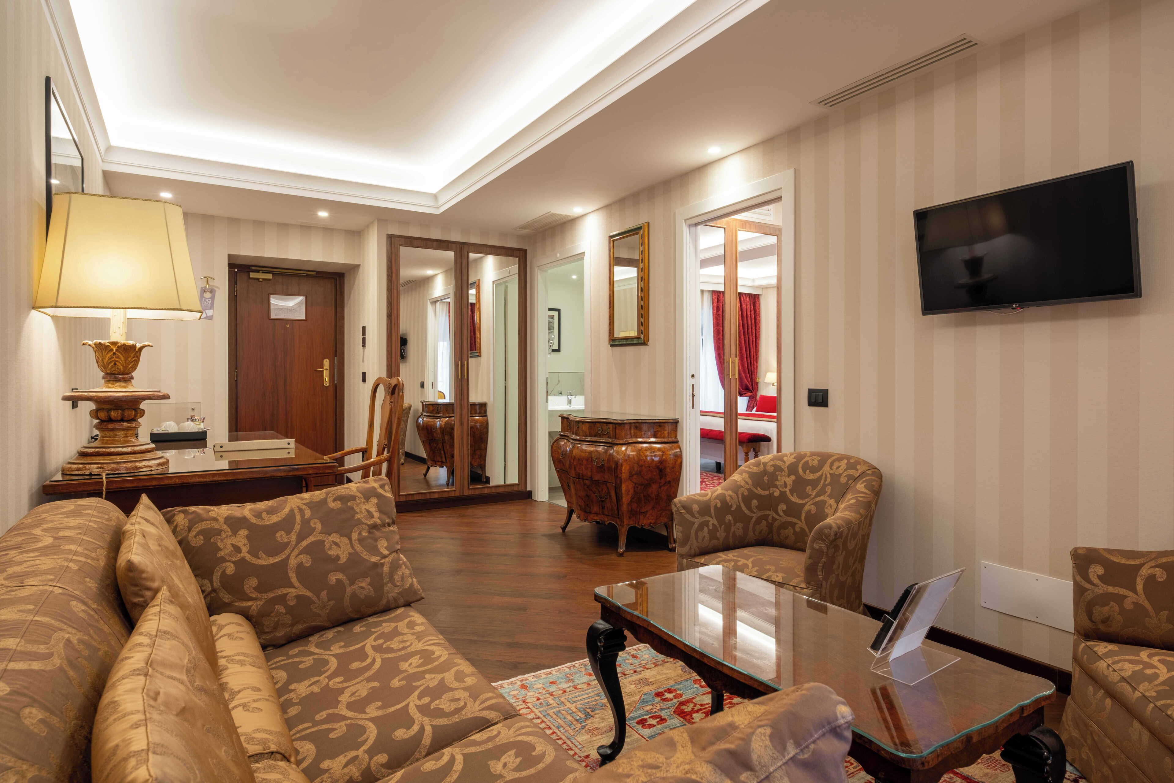 Uma sala de estar ampla com sofá, poltronas, mesa de centro e televisão.