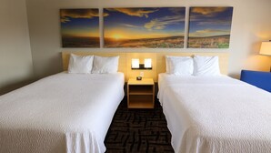 Quarto de hotel com duas camas, mesa de cabeceira com abajures e uma grande pintura de paisagem acima das camas.