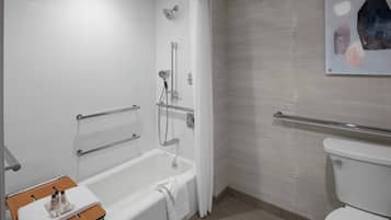 Uma casa de banho moderna com banheira, chuveiro e sanita.