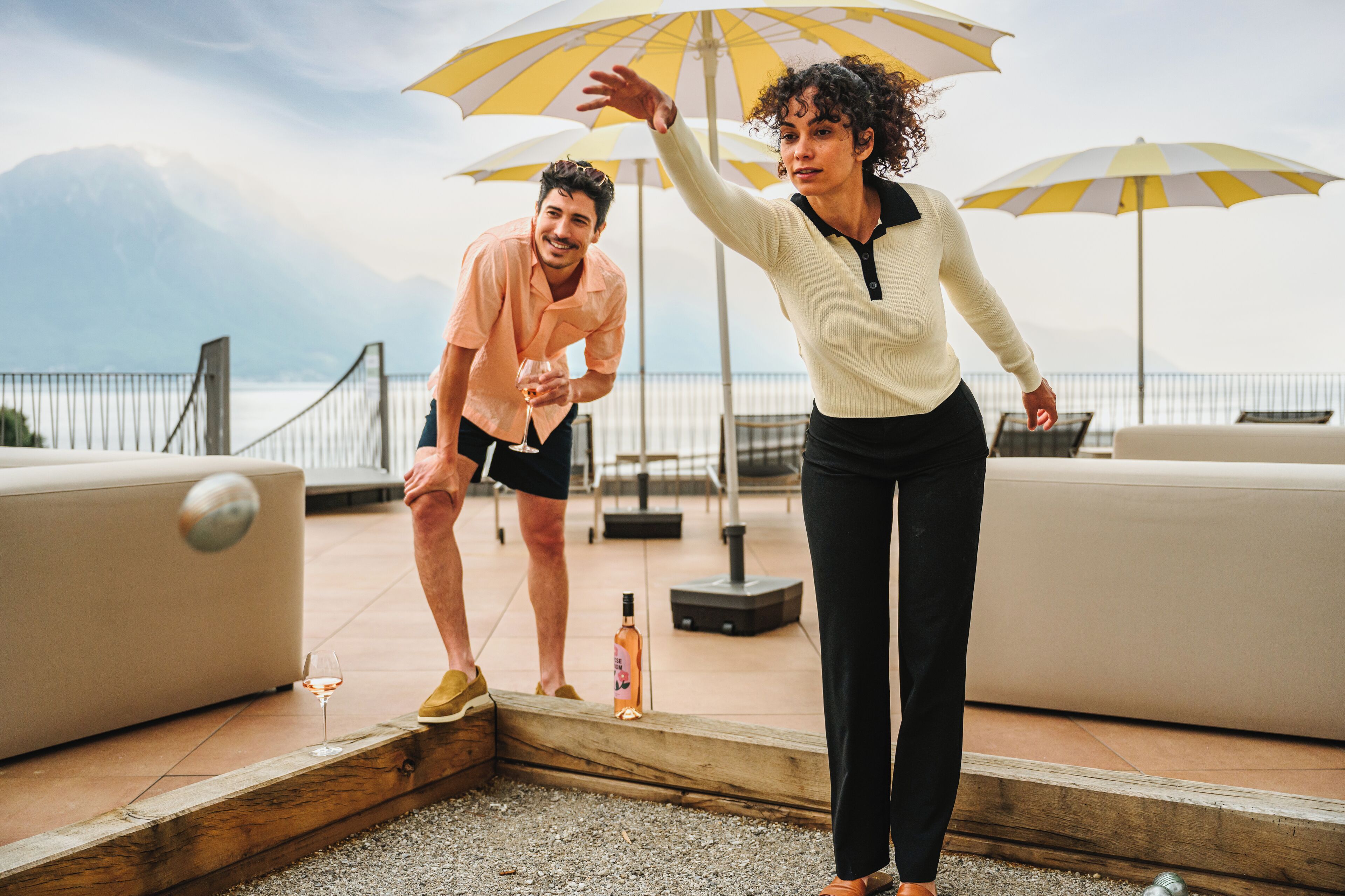 Terraço no telhado com duas pessoas, uma mesa e um guarda-sol.
