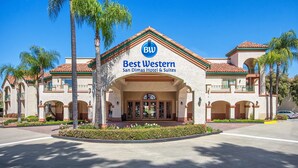 Um hotel com um grande letreiro Best Western, várias varandas e uma área de jardim bem cuidada.