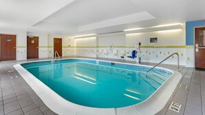 Piscina com profundidade de 1,2 metros, rodeada por um deck revestido de azulejos, e um teto inclinado.